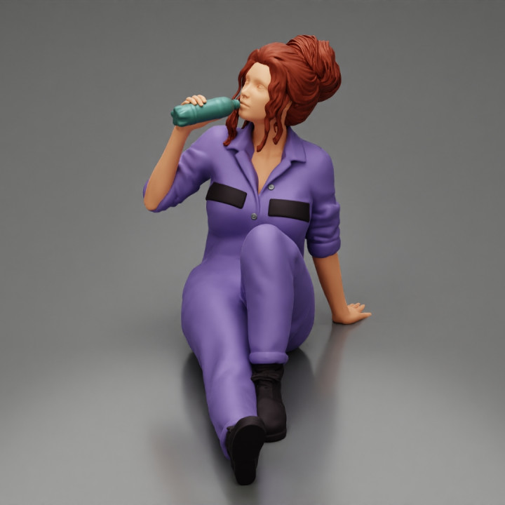 3D Printable Tired woman mechanic sitting and drinking water during ...