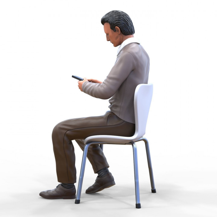 3D Printable A Man sitting on a chair with smartphone by 3DP Miniatures