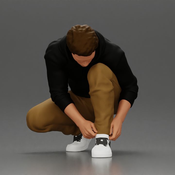 3D Printable Man in hoodie crouching down tying shoelaces focused in ...